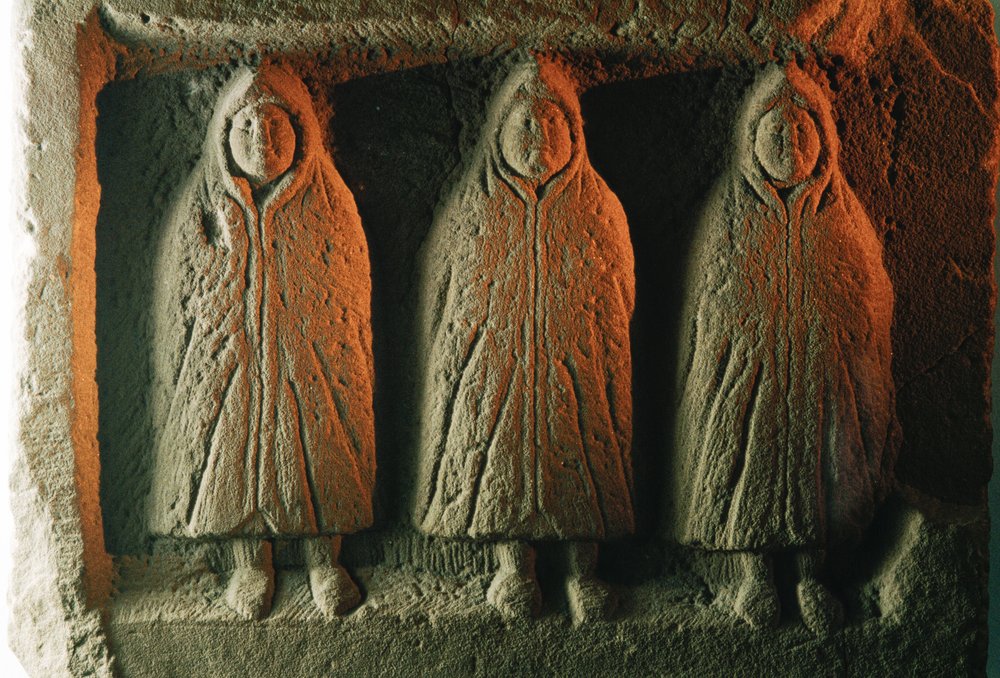 A relief sculpture depicting local deities cloaked against the cold ...