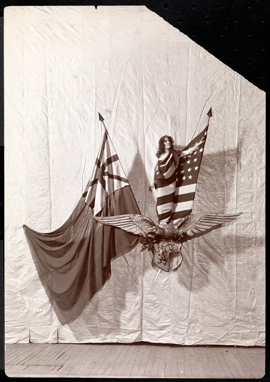 A Living Picture: a model draped in the American Flag standing atop a ...