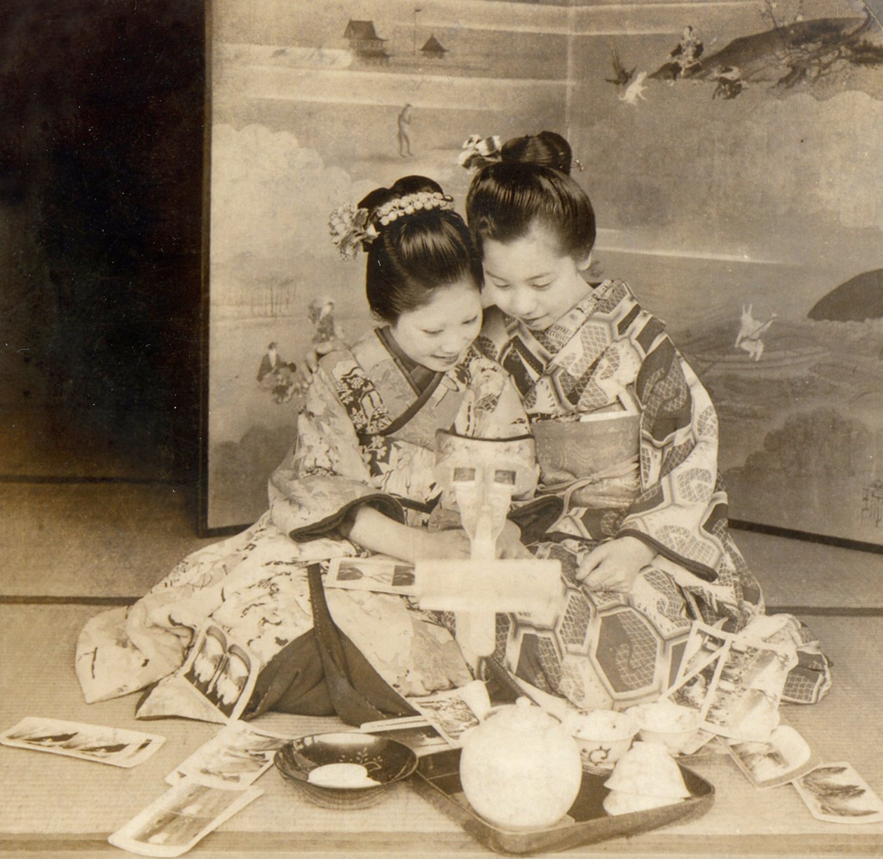 Japanese girls using a stereoscope viewer with stereographic cards
