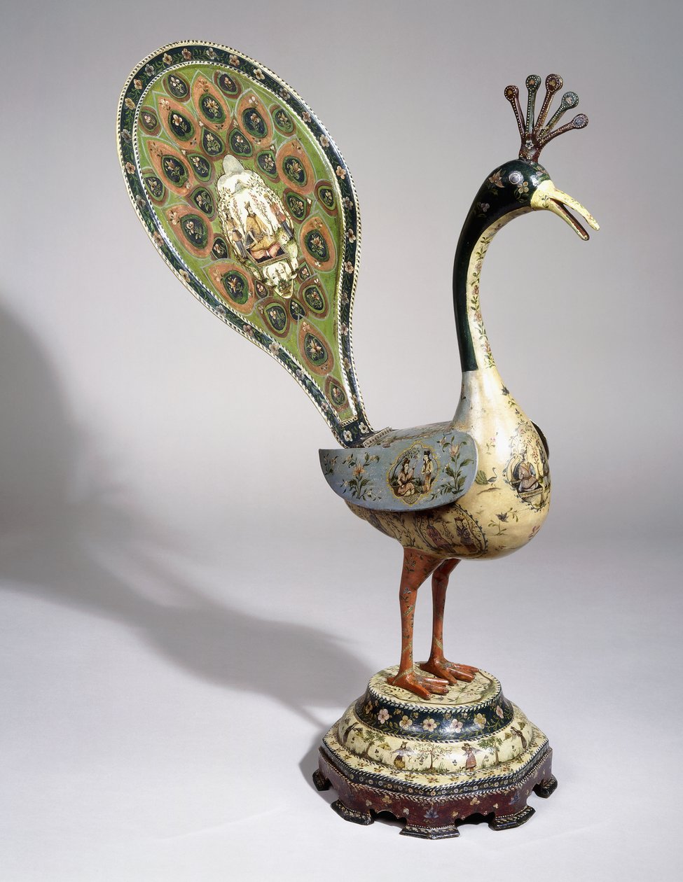 A Qajar peacock painted with flower designs, and pictorial cartouches ...